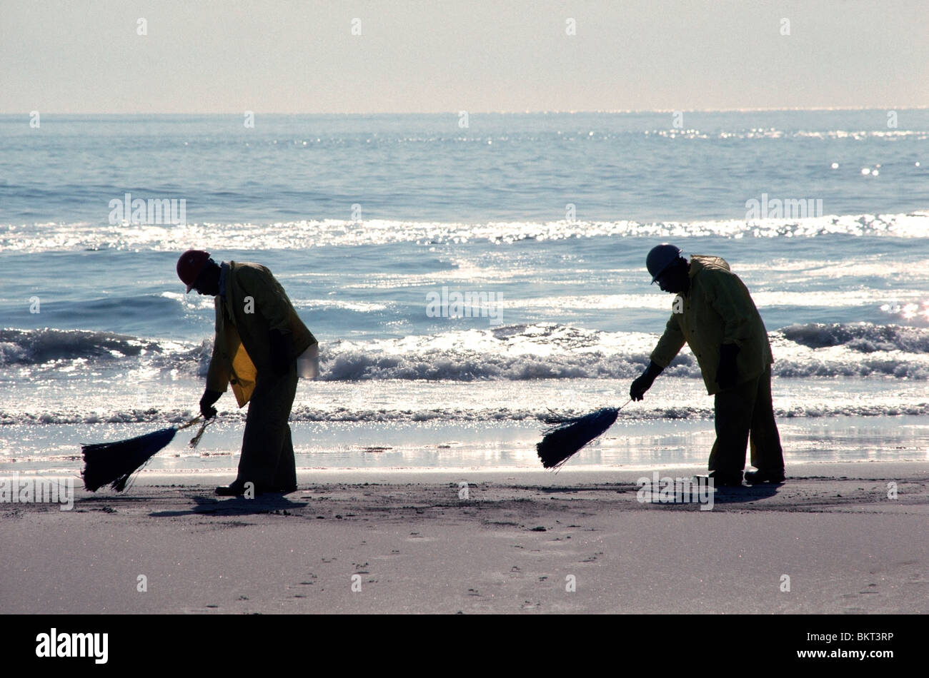Cleanup workers sweeping the sand on Huntington Beach after the 1990 ...