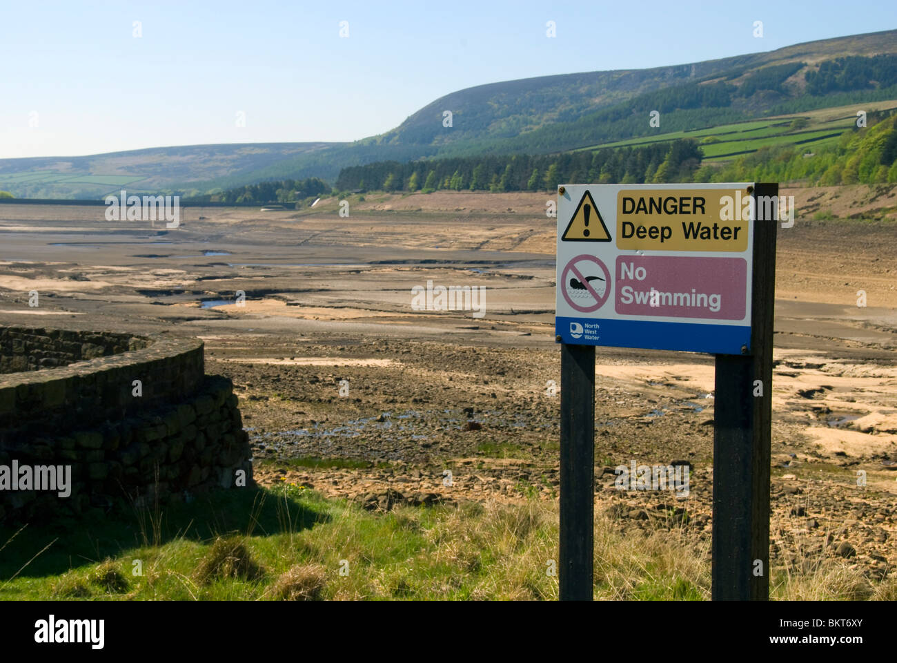 'Deep Water' and 'No Swimming' signs by an empty reservoir. Torside ...