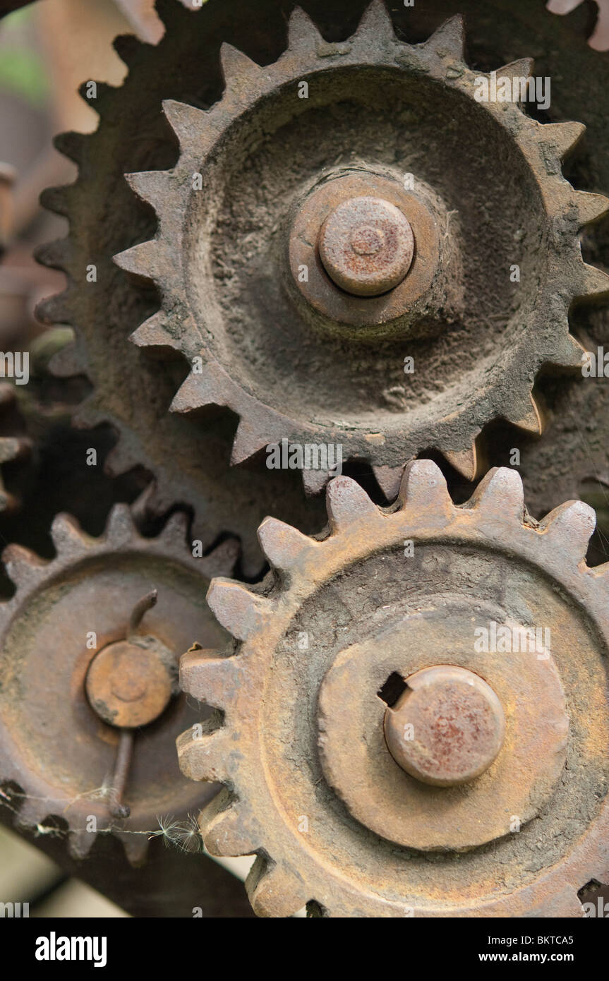 Antique cogs and gears lie exposed to the elements on an antique piece ...