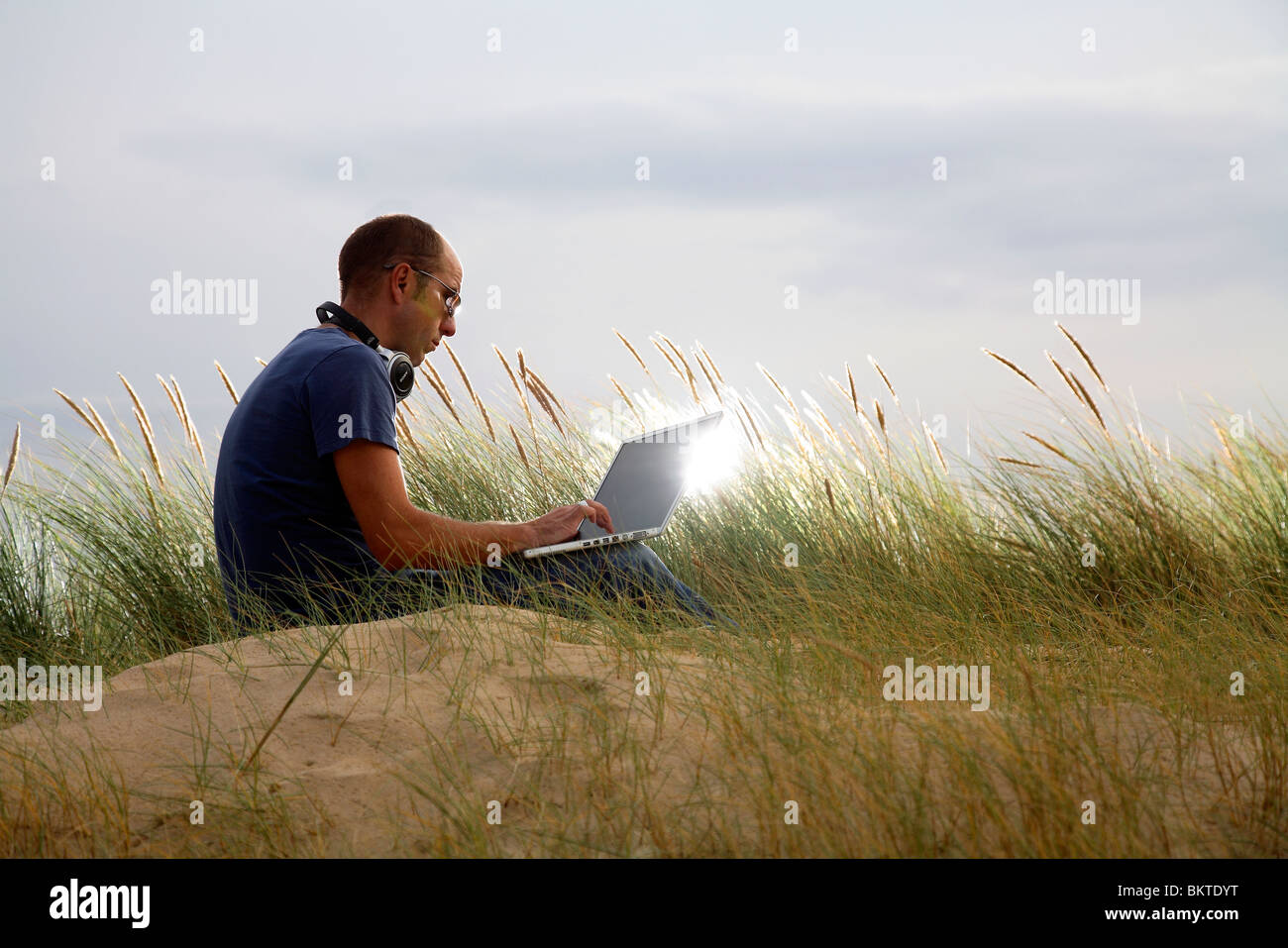 man on beach using laptop Stock Photo - Alamy