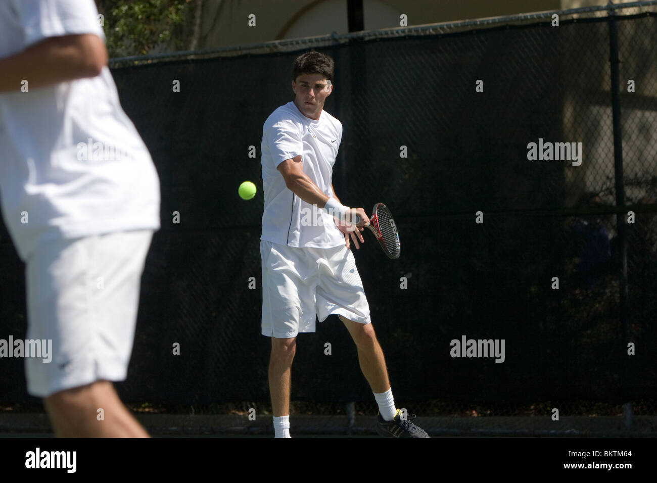 Male tennis player returning a ball Stock Photo - Alamy