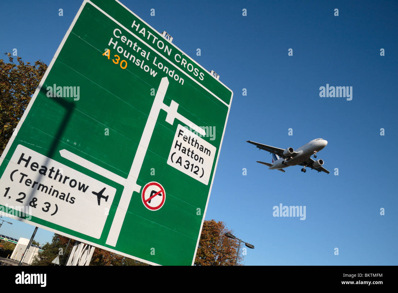 An Air France airplane passes an A30 road sign beside Heathrow Airport ...