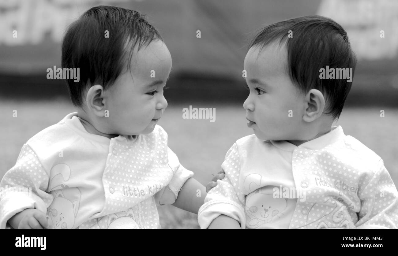 Two babies absorbed in a conversation Stock Photo - Alamy