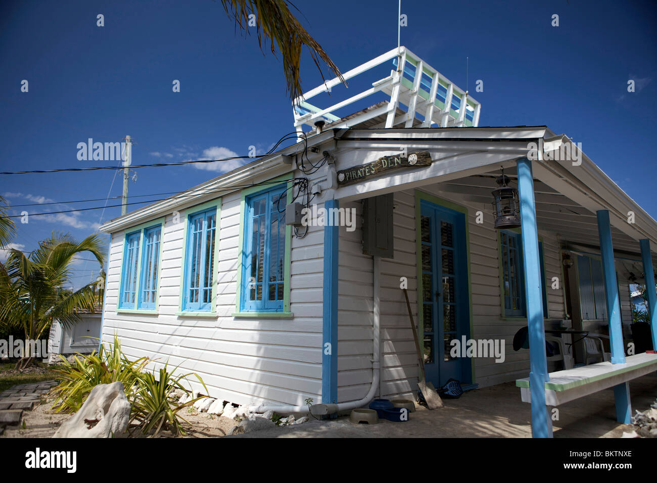 A white and blue wooden island house called the Pirate's Den on Man O ...