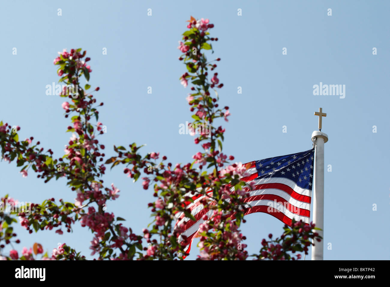 The Catholic church with a cross and US flag on a flagpole with ...