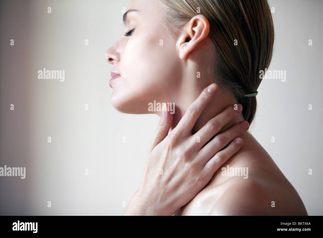 Young woman with hands on neck,eyes closed Stock Photo - Alamy