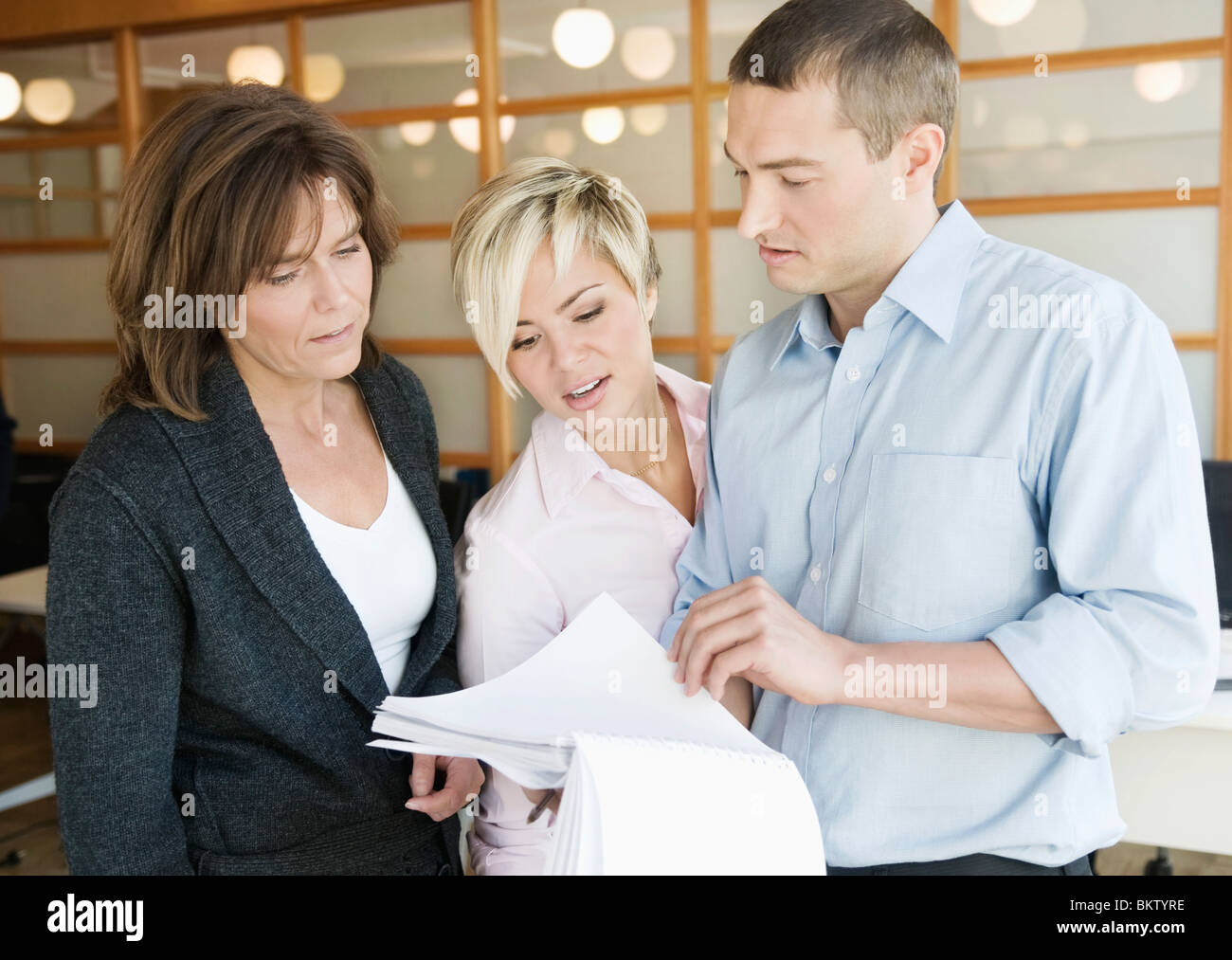 Colleagues looking at document Stock Photo - Alamy