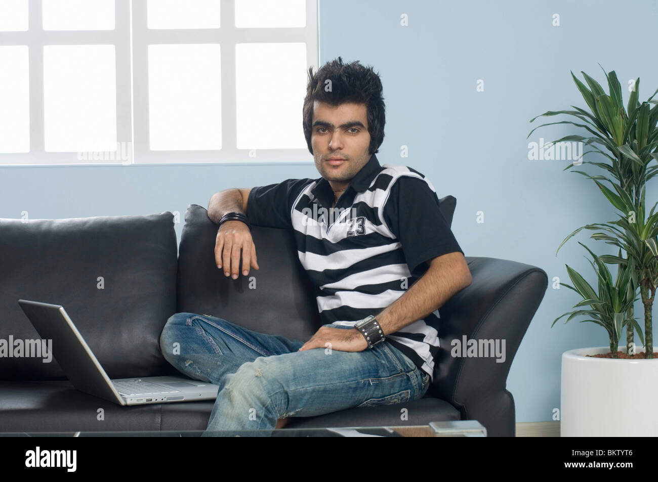 Young man sitting in front of laptop, portrait Stock Photo - Alamy