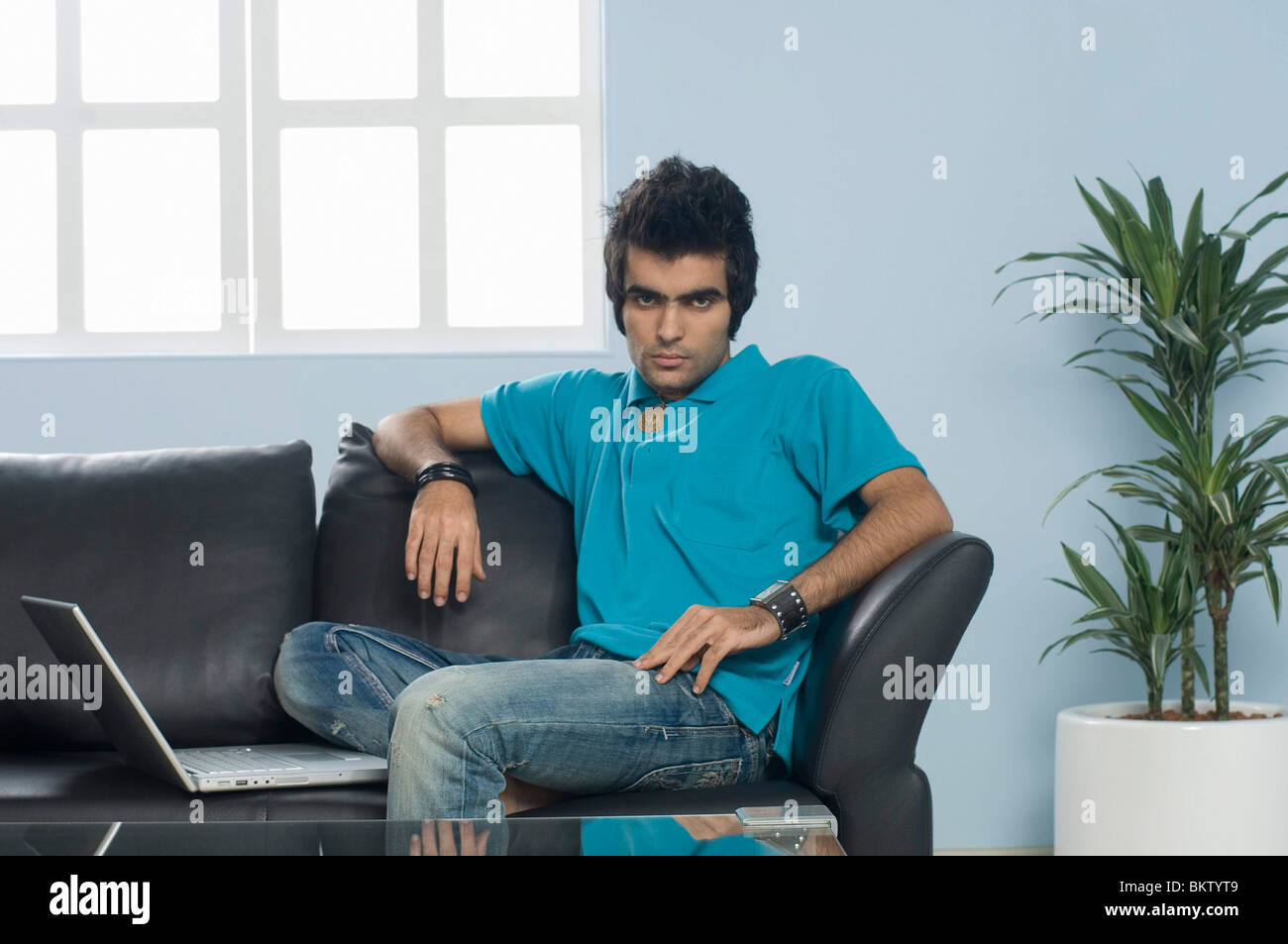 Young man sitting in front of laptop, portrait Stock Photo - Alamy