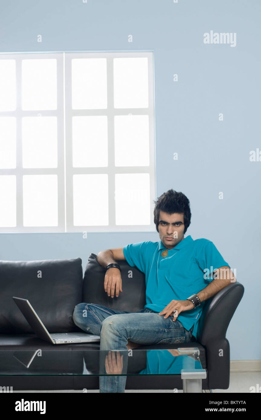 Young man sitting in front of laptop, portrait Stock Photo - Alamy