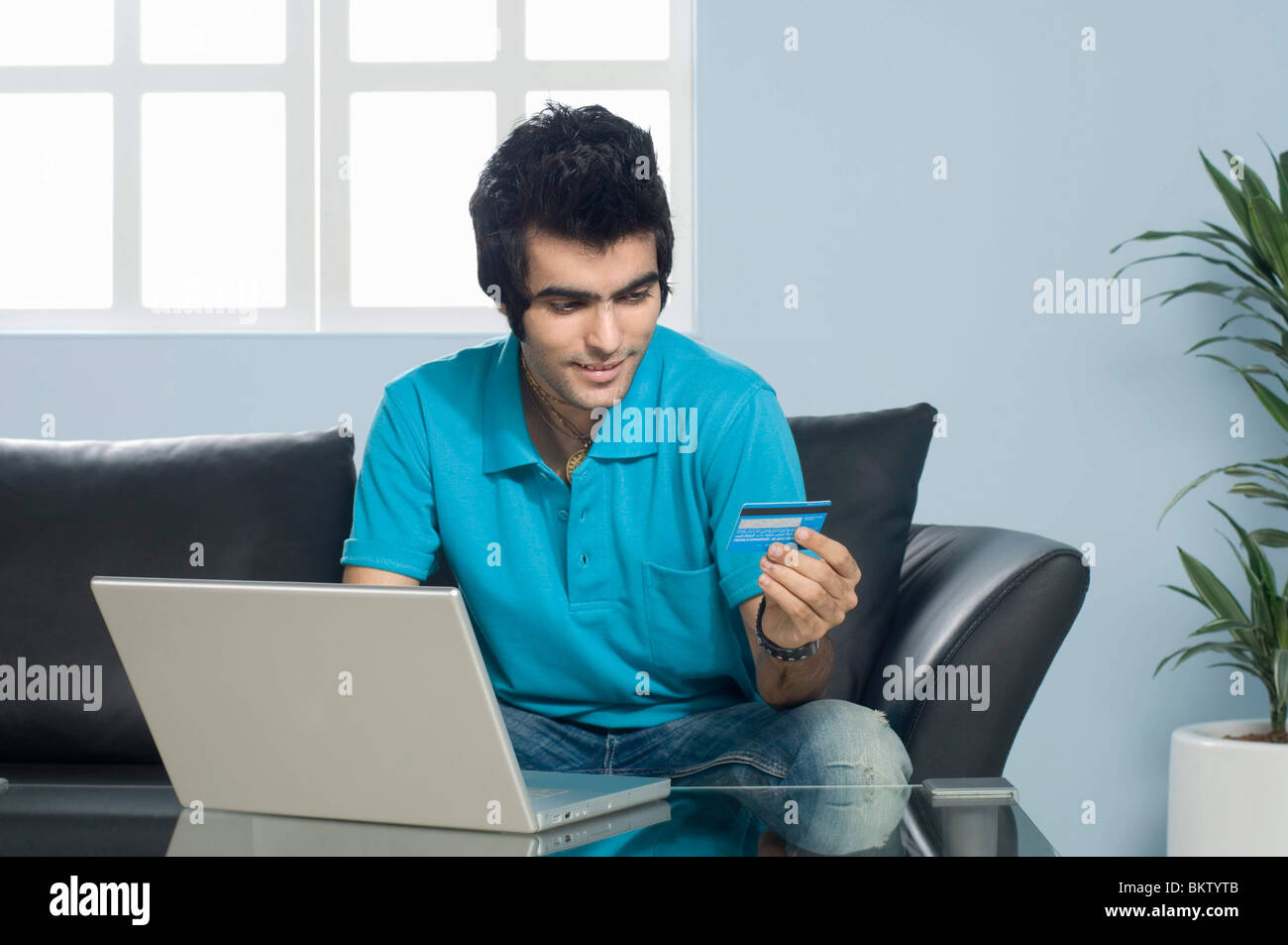 Young man holding credit card Stock Photo - Alamy