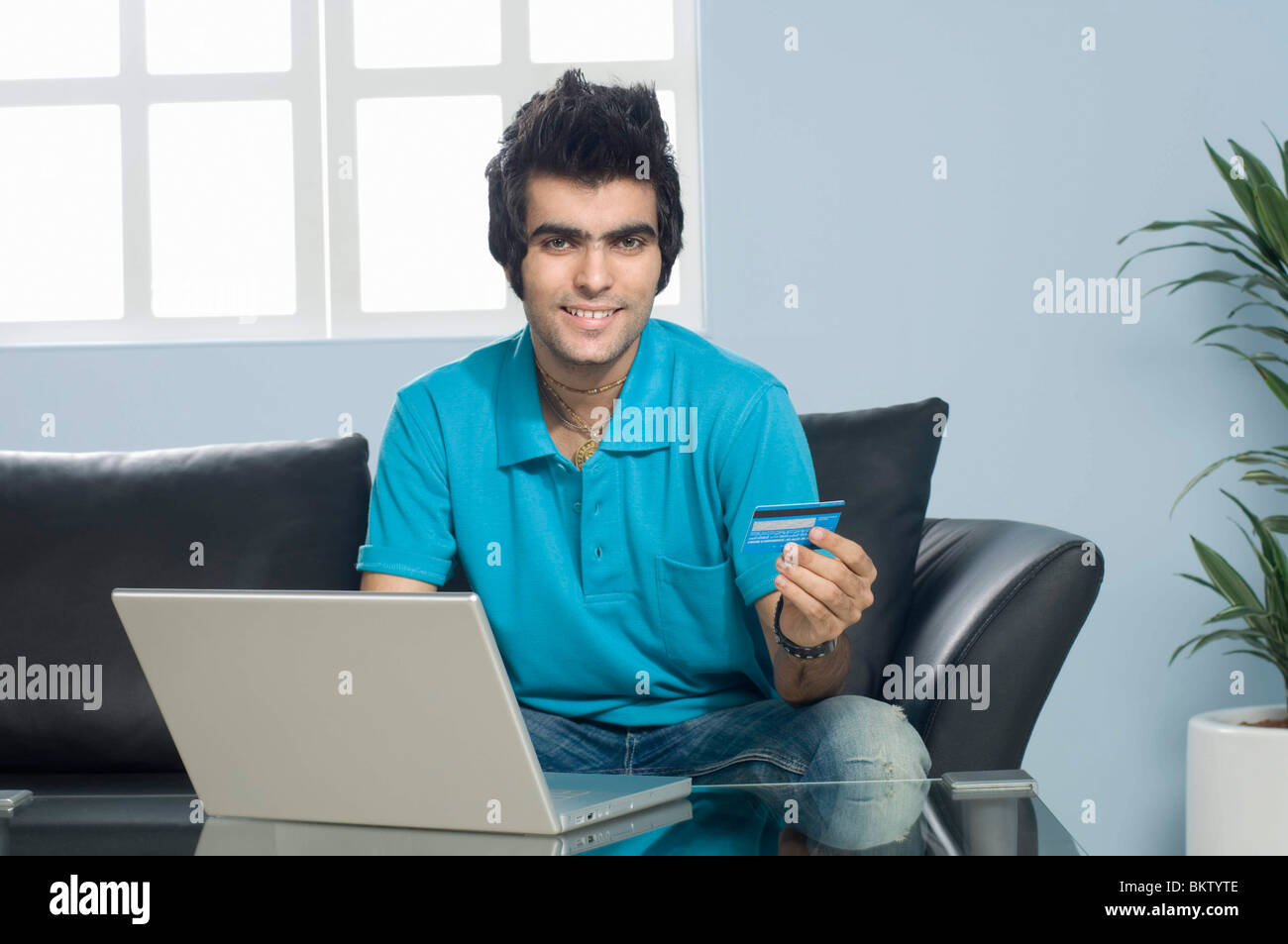 Young man holding credit card, smiling, portrait Stock Photo - Alamy