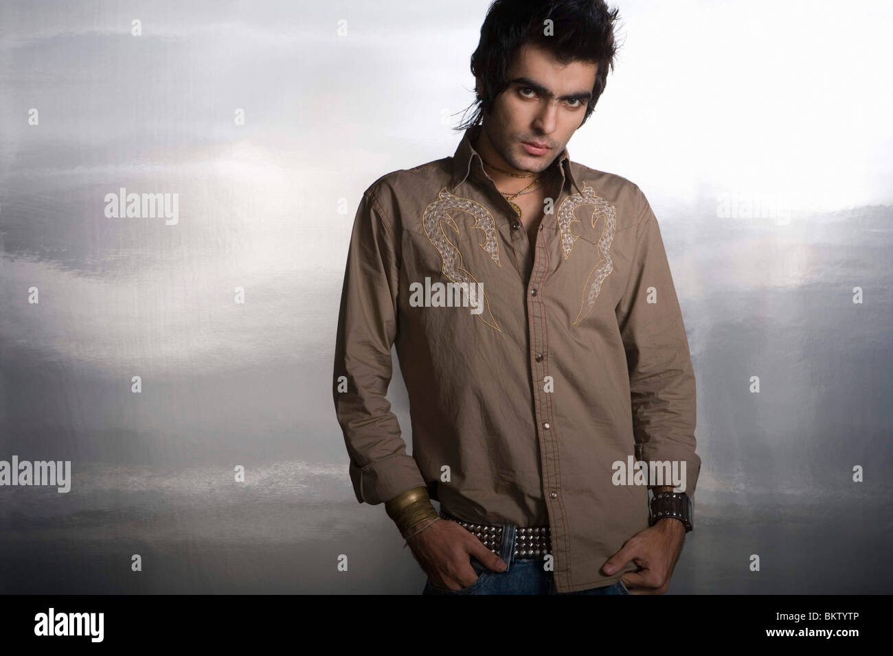 Young man standing against colored background, portrait Stock Photo - Alamy