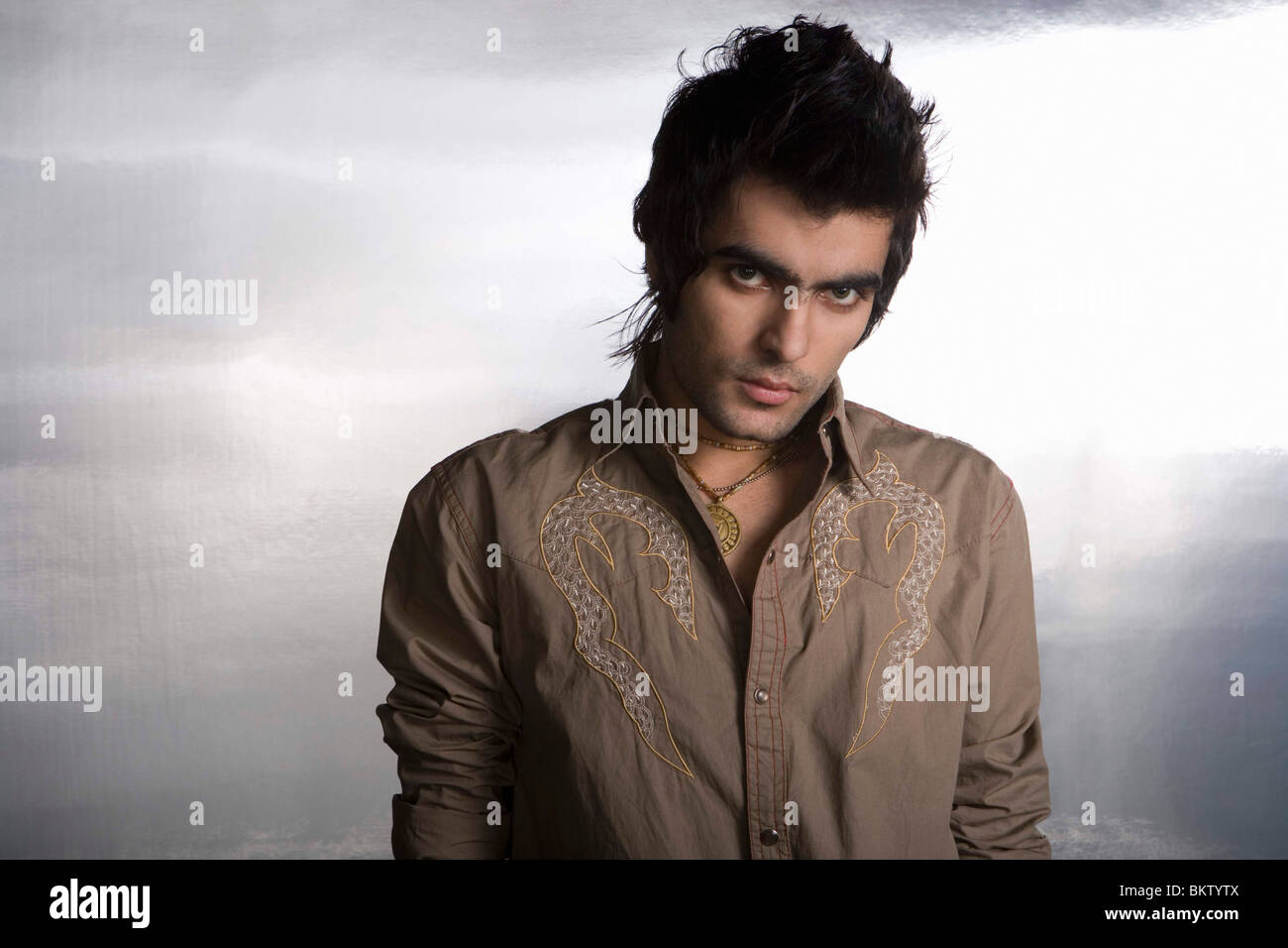 Young man standing against colored background Stock Photo - Alamy