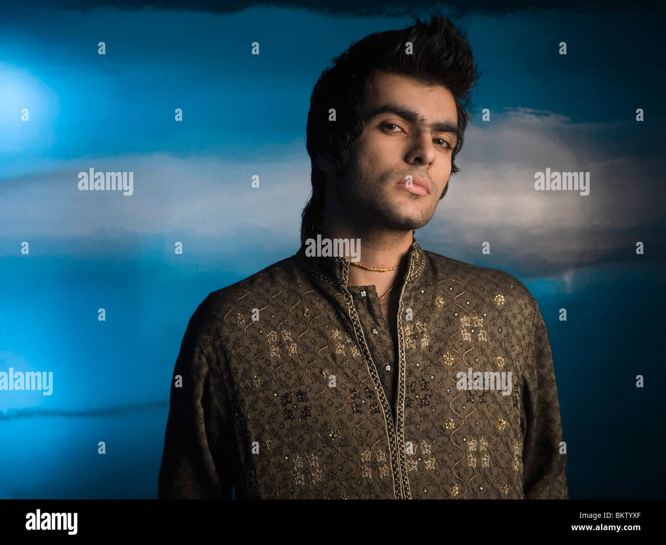 Young man standing against colored background, portrait Stock Photo - Alamy