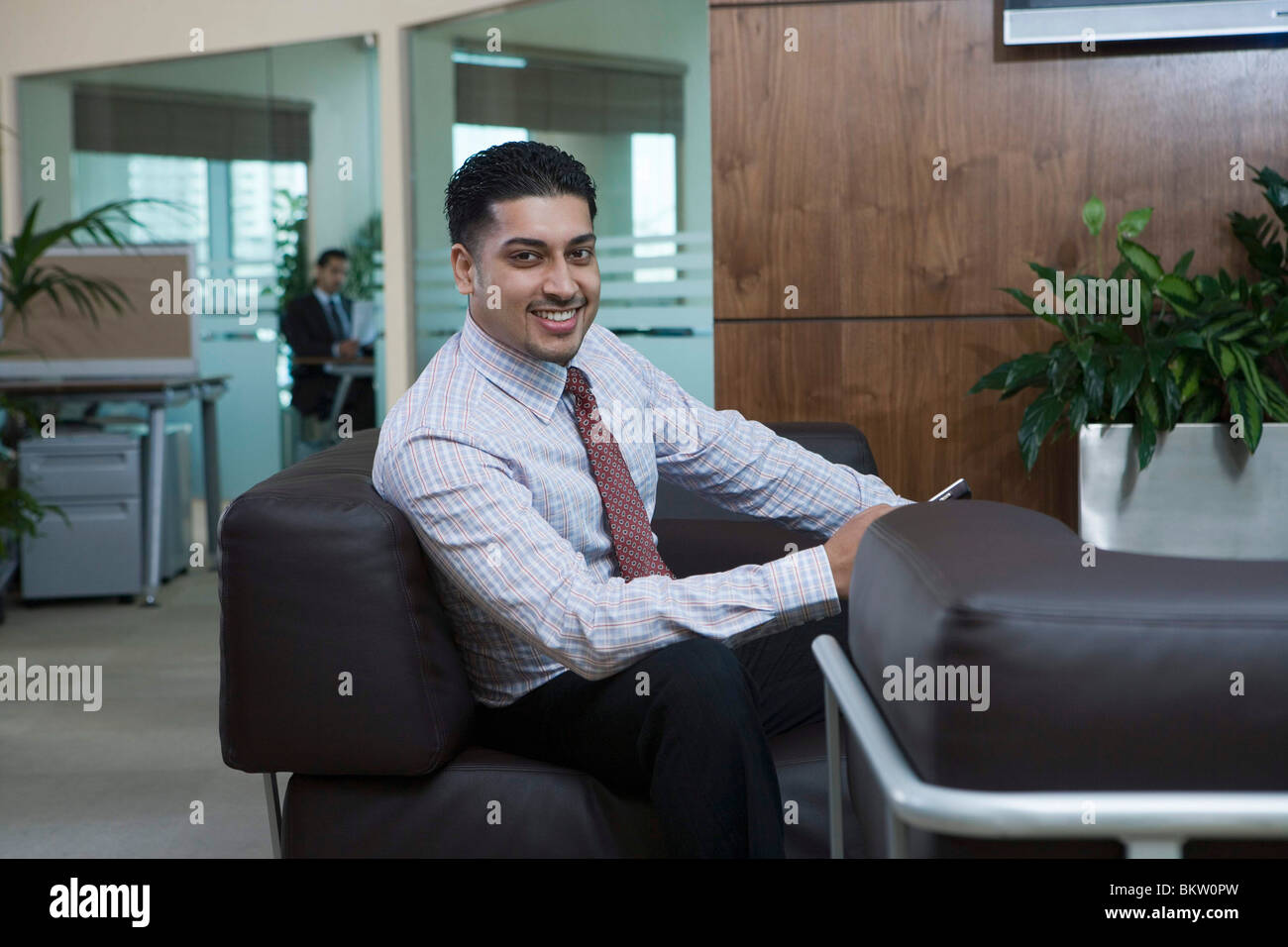 Businessman sitting in office, portrait Stock Photo - Alamy