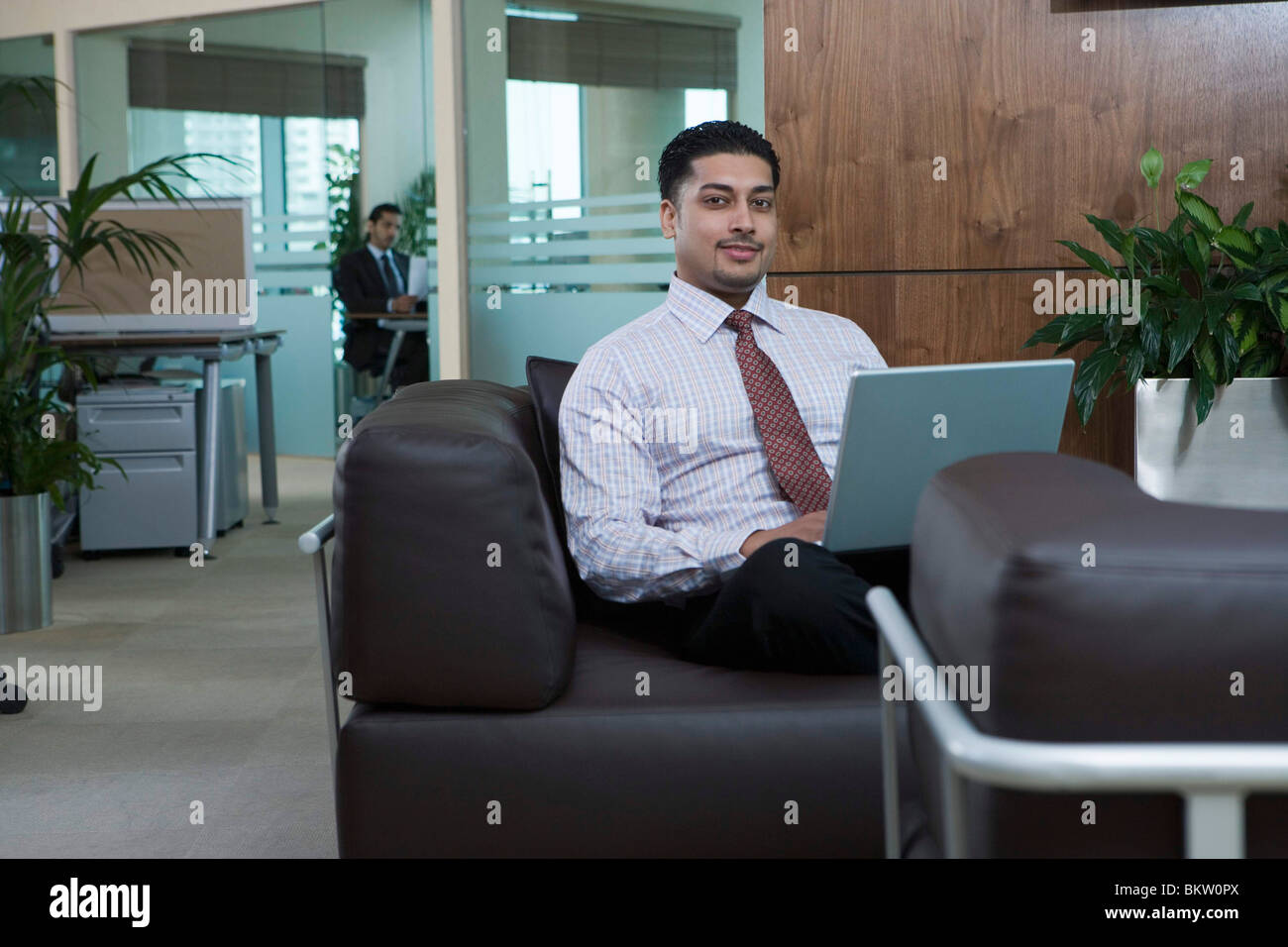 Businessman using laptop in office, portrait Stock Photo - Alamy