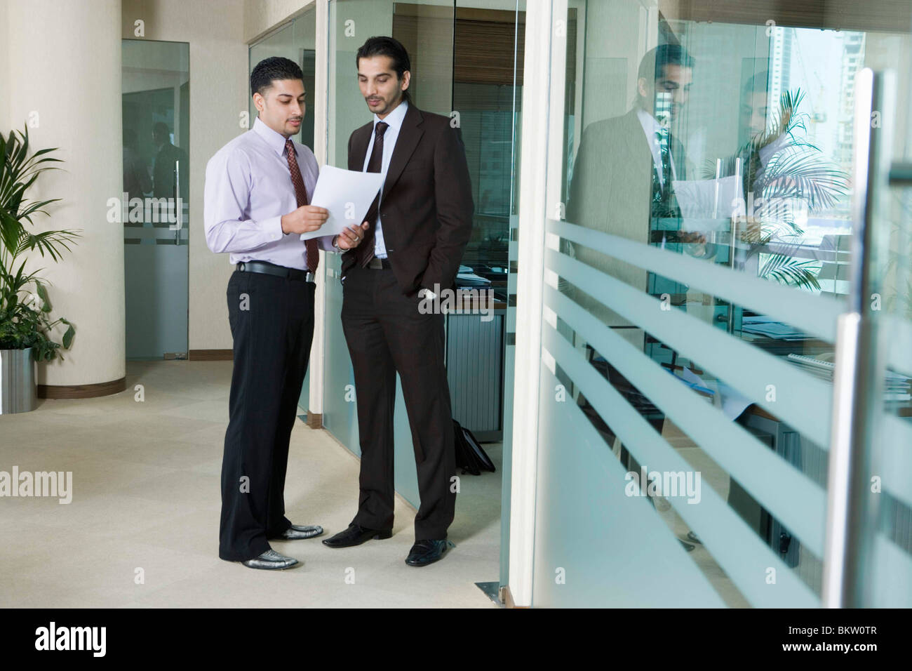 Businessmen looking at document in office Stock Photo - Alamy