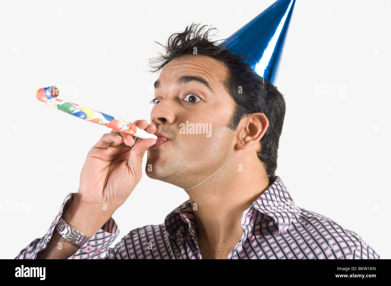 Young man blowing party horn blower, close-up Stock Photo - Alamy