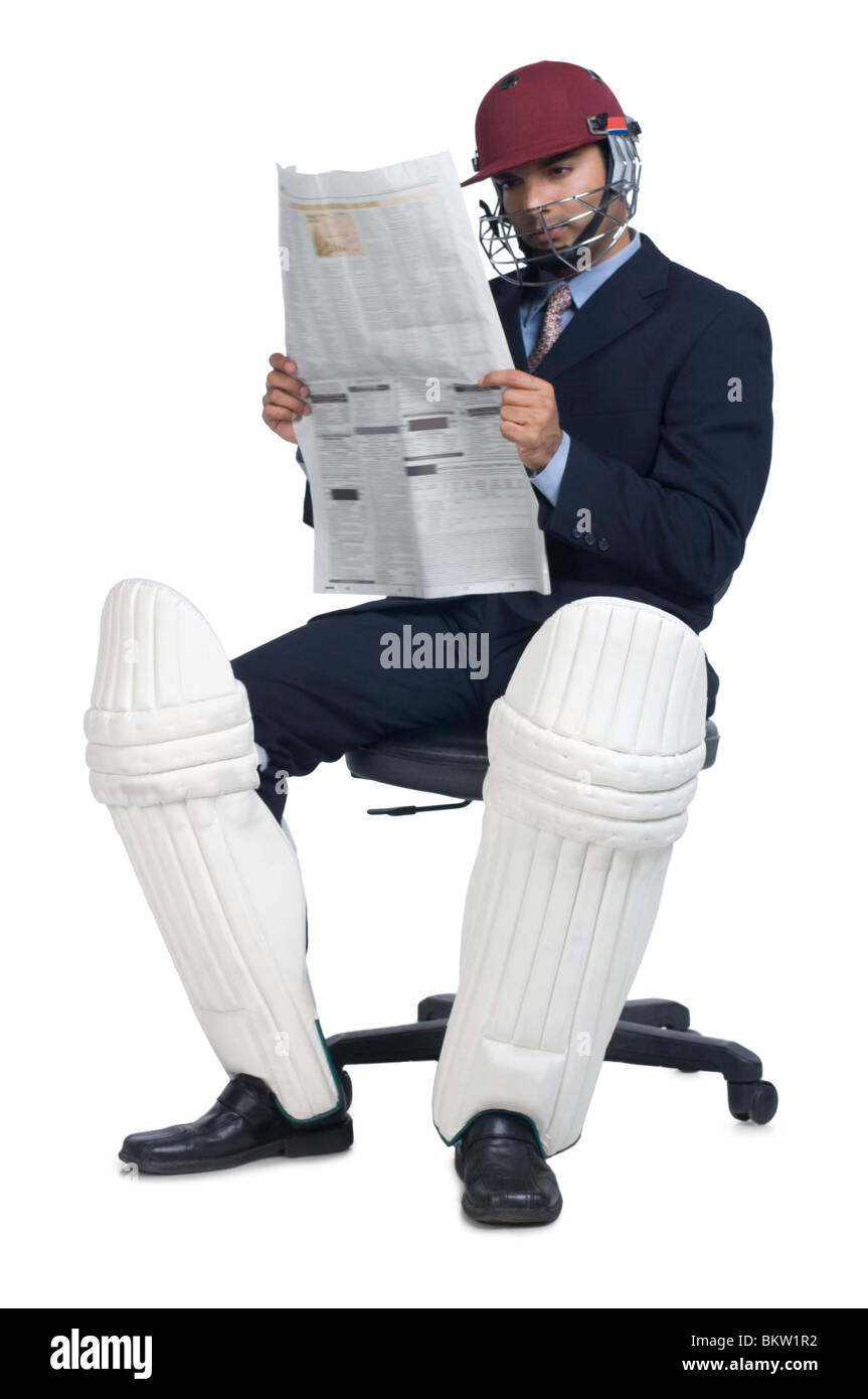 Businessman wearing sports helmet, reading newspaper Stock Photo - Alamy