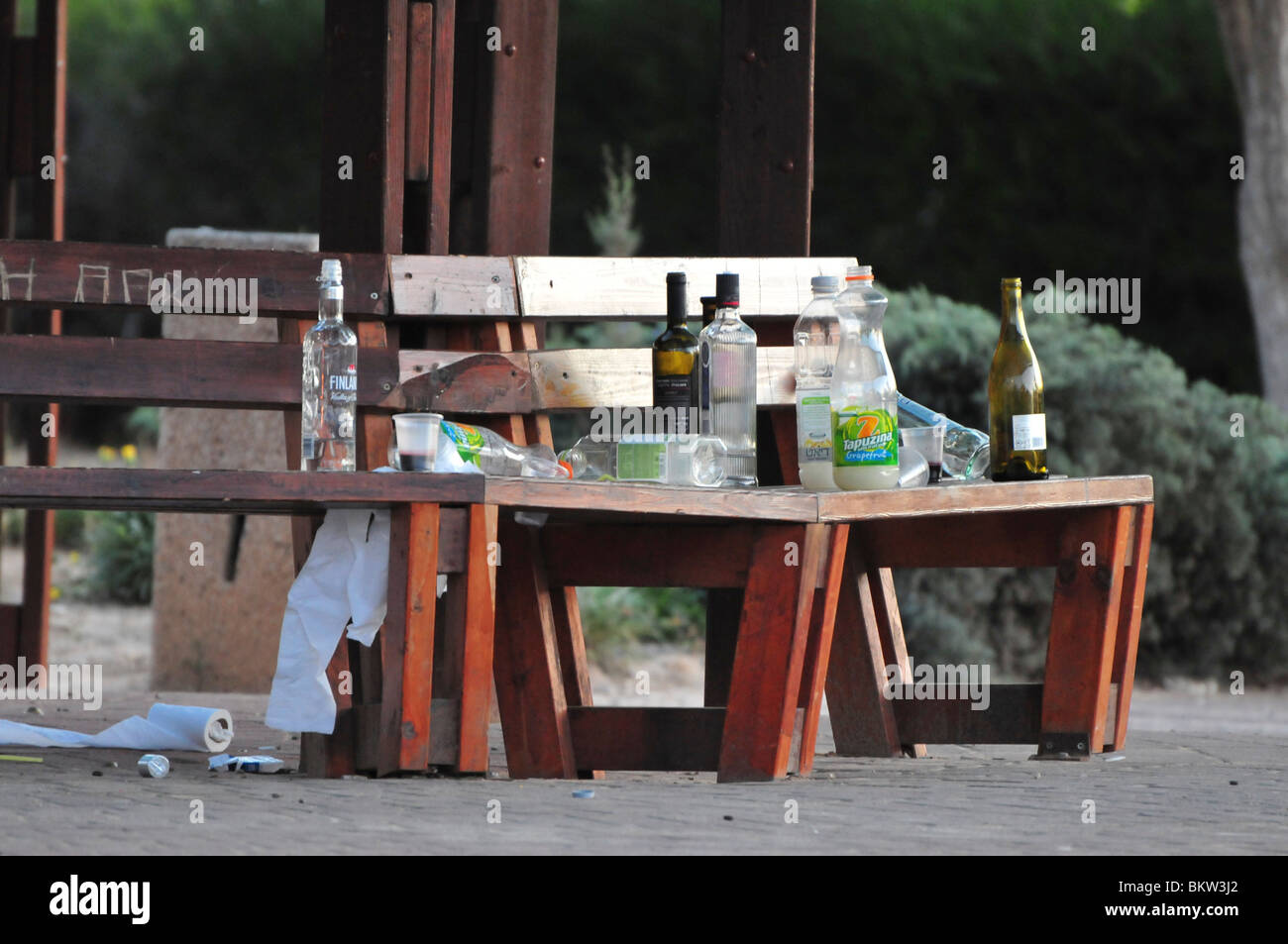 Empty alcohol bottles on a park bench Stock Photo - Alamy