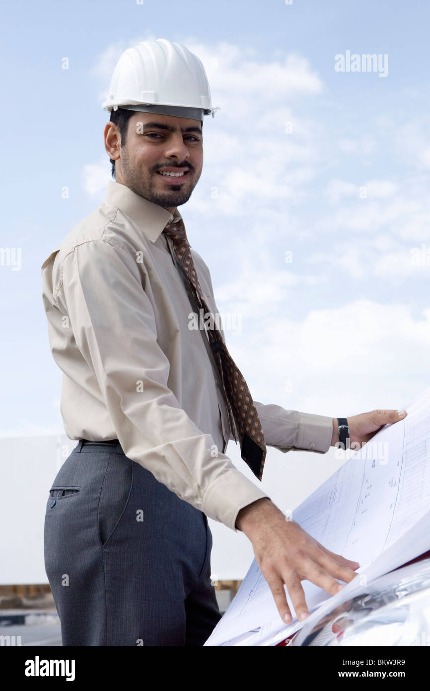 Young man with blueprint, portrait Stock Photo - Alamy