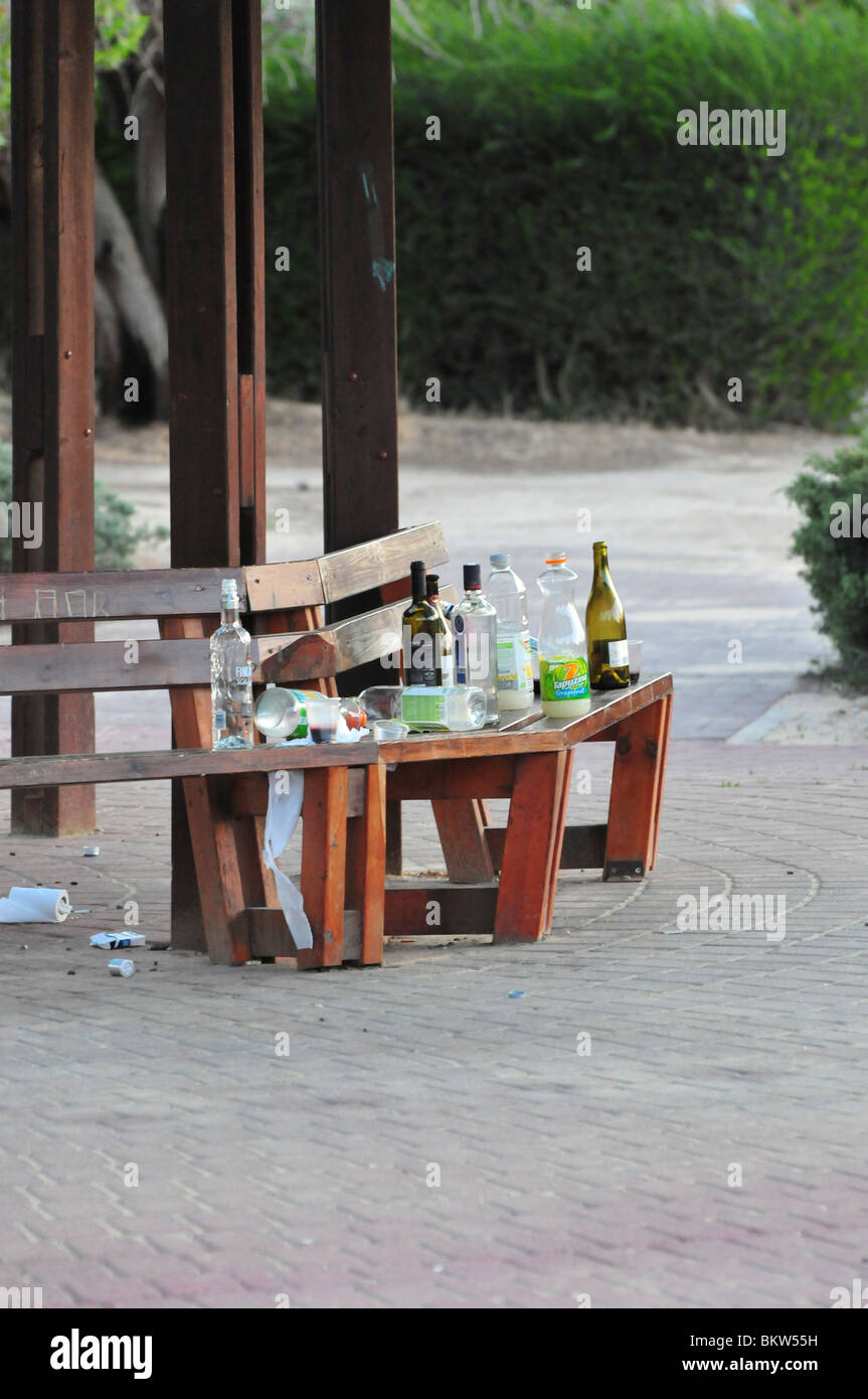 Empty alcohol bottles on a park bench Stock Photo - Alamy