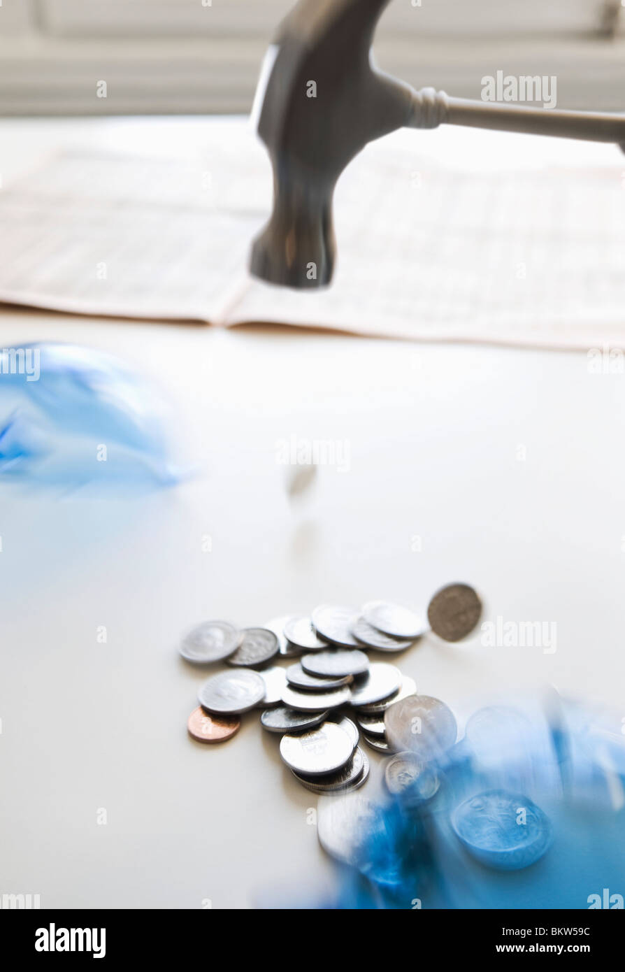 Hammer hitting coins Stock Photo - Alamy