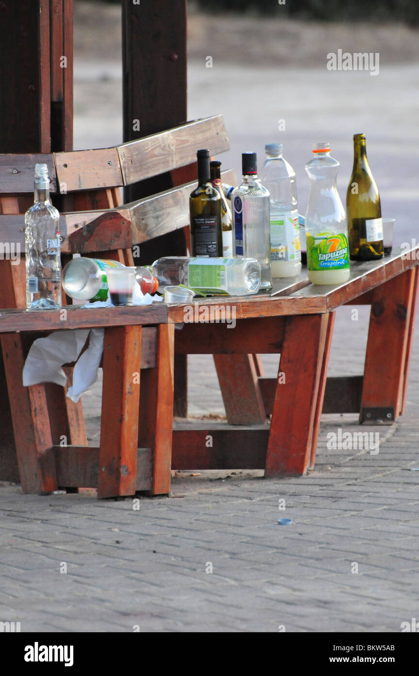 Empty alcohol bottles on a park bench Stock Photo - Alamy