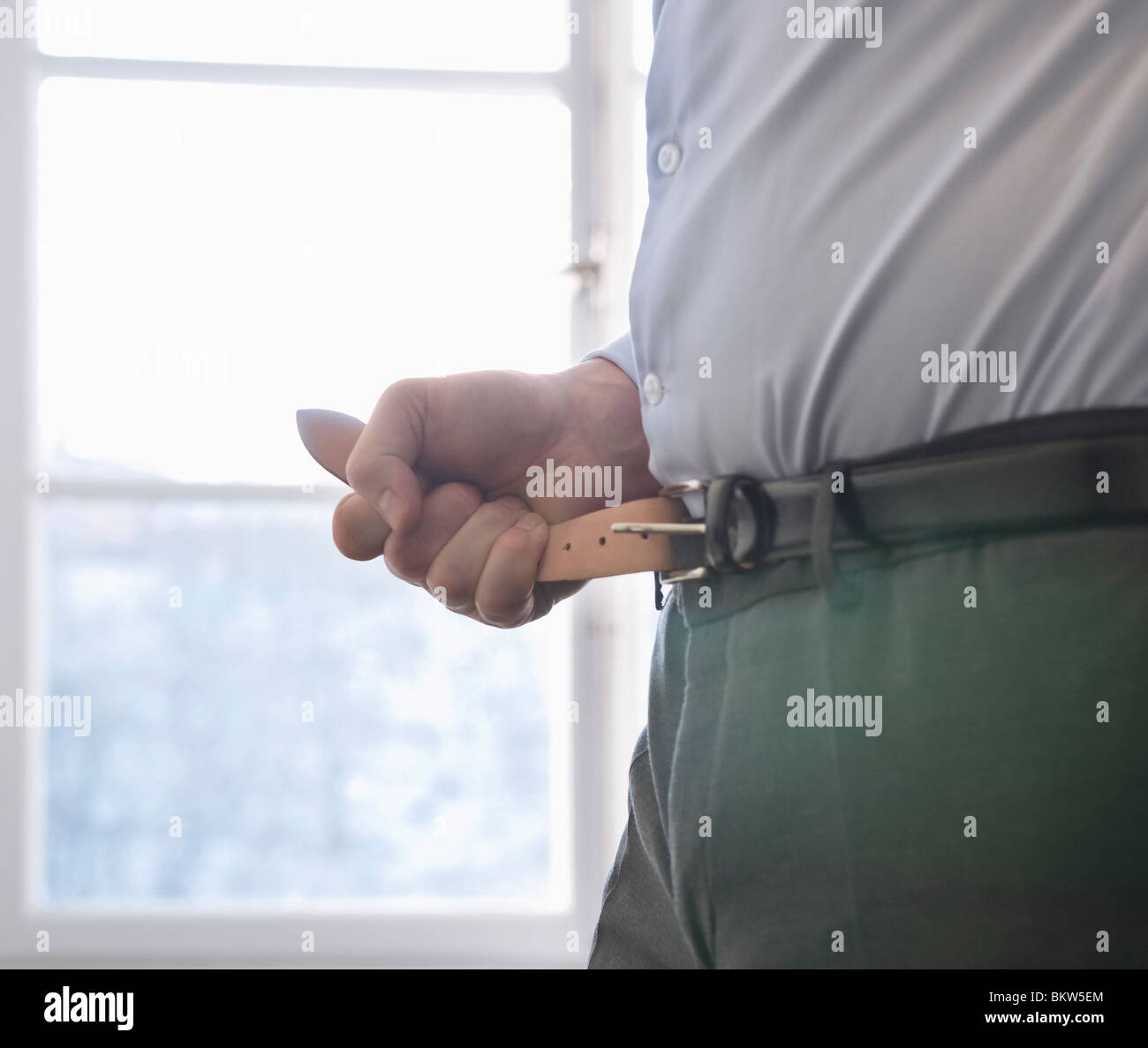 Man fasten his belt Stock Photo - Alamy