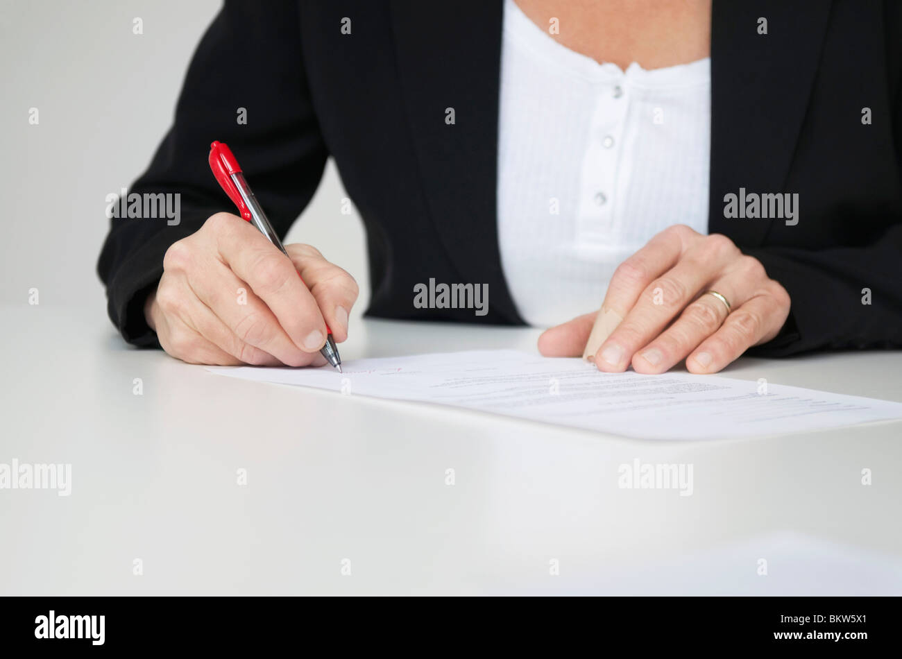 Woman signing paper Stock Photo - Alamy