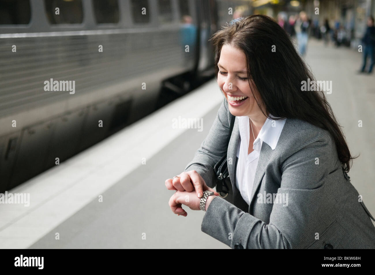 Woman laughing and checking the time Stock Photo - Alamy