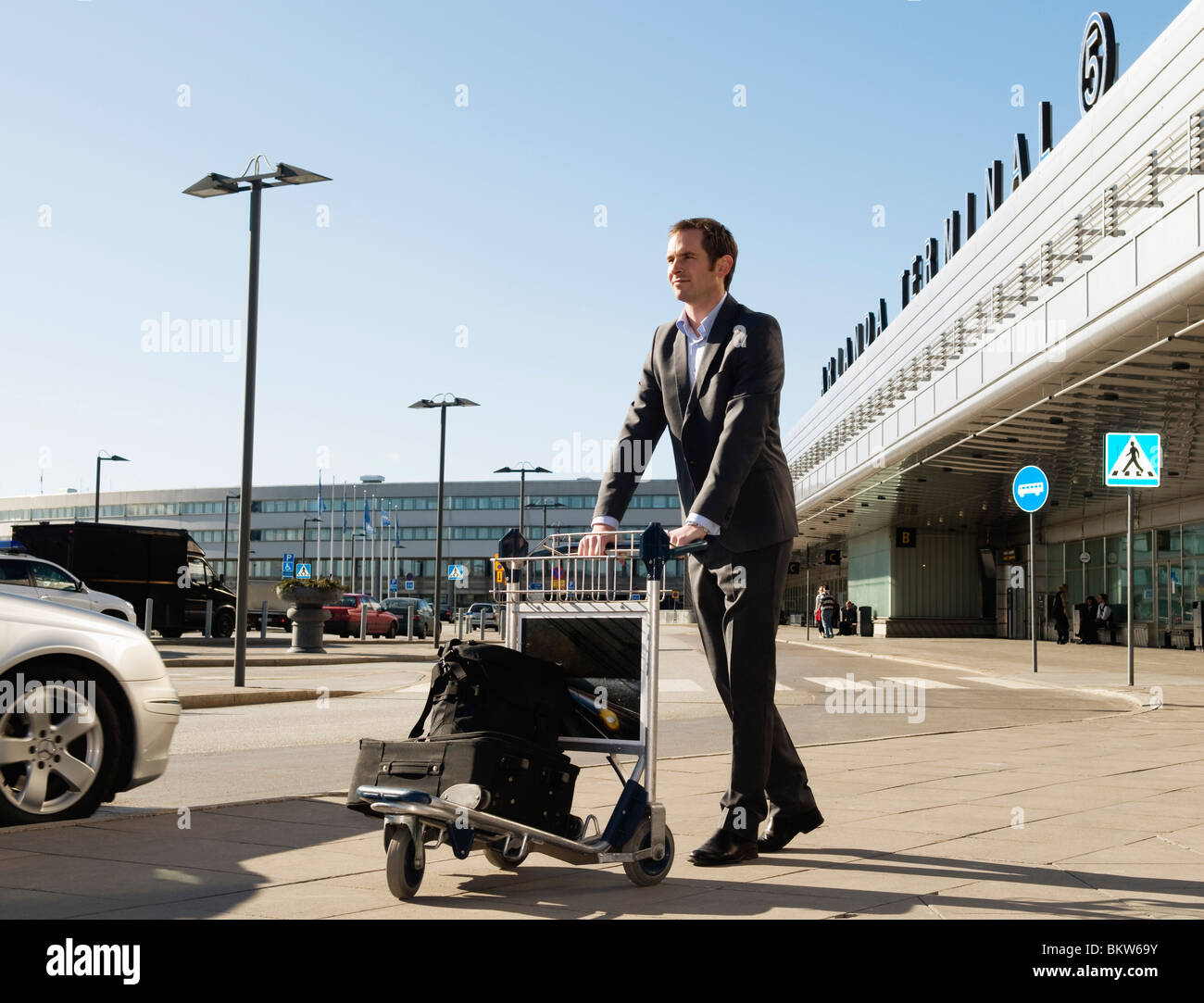 Man with trolley at parking lot Stock Photo - Alamy