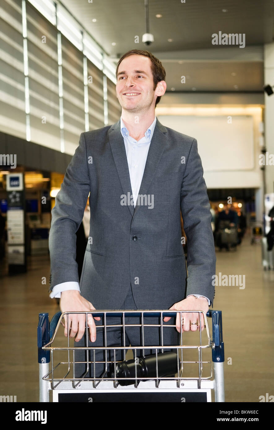 Businessman pushing luggage on trolley hi-res stock photography and ...