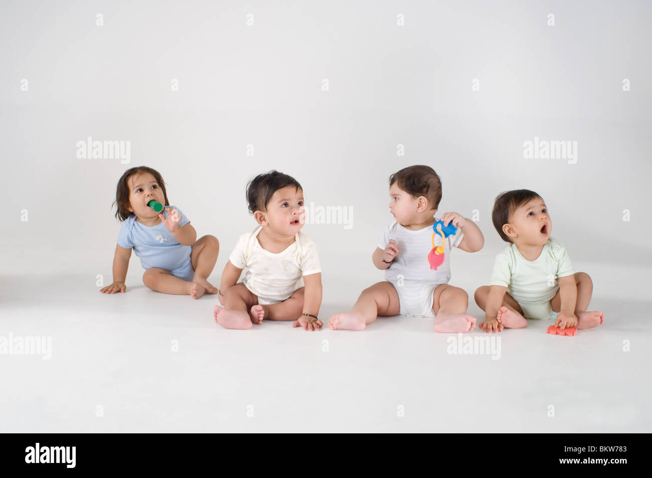 Four babies sitting together Stock Photo - Alamy