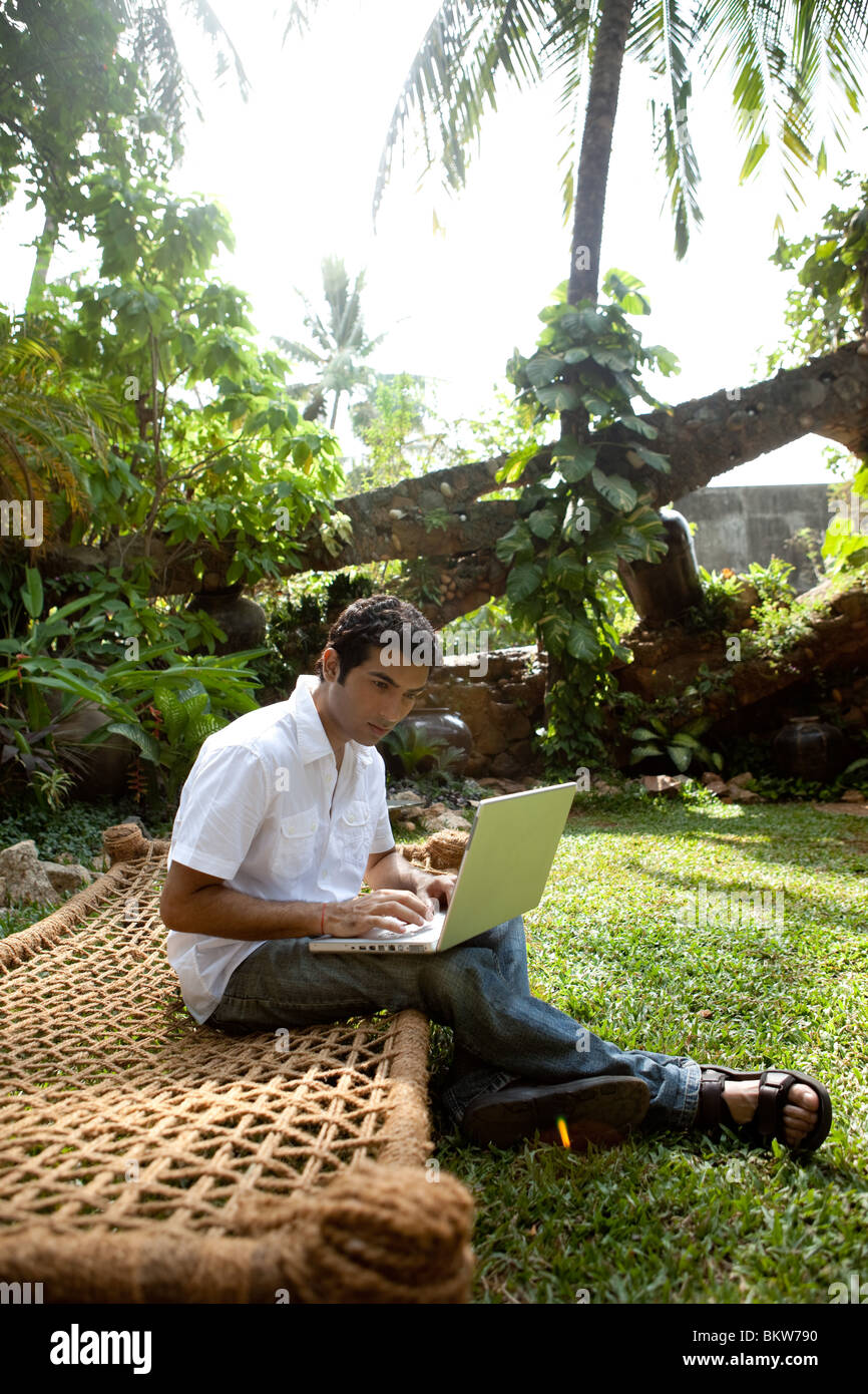 Man with laptop sitting in the garden Stock Photo - Alamy