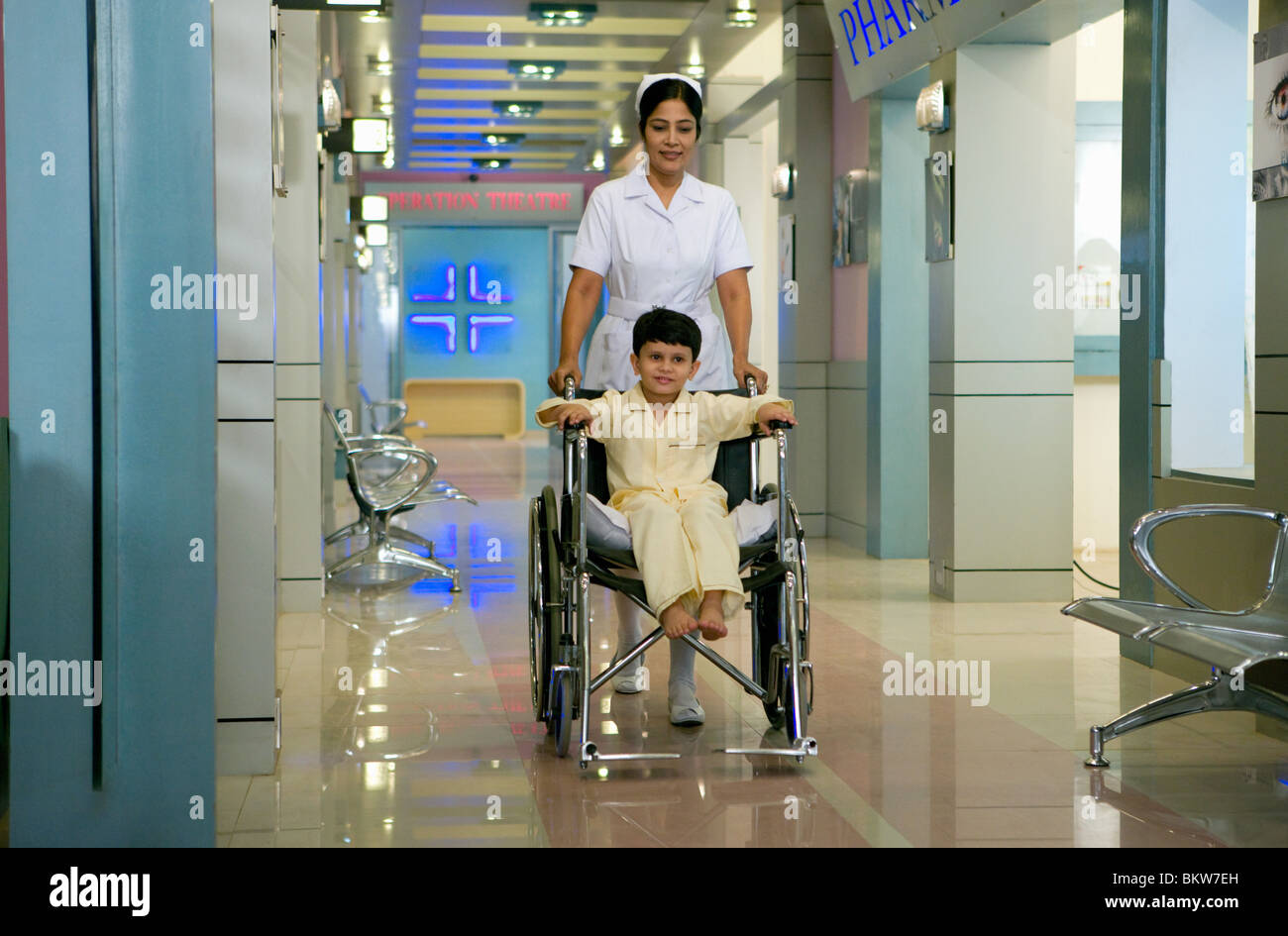 Female nurse pushing the wheelchair of a boy patient Stock Photo - Alamy