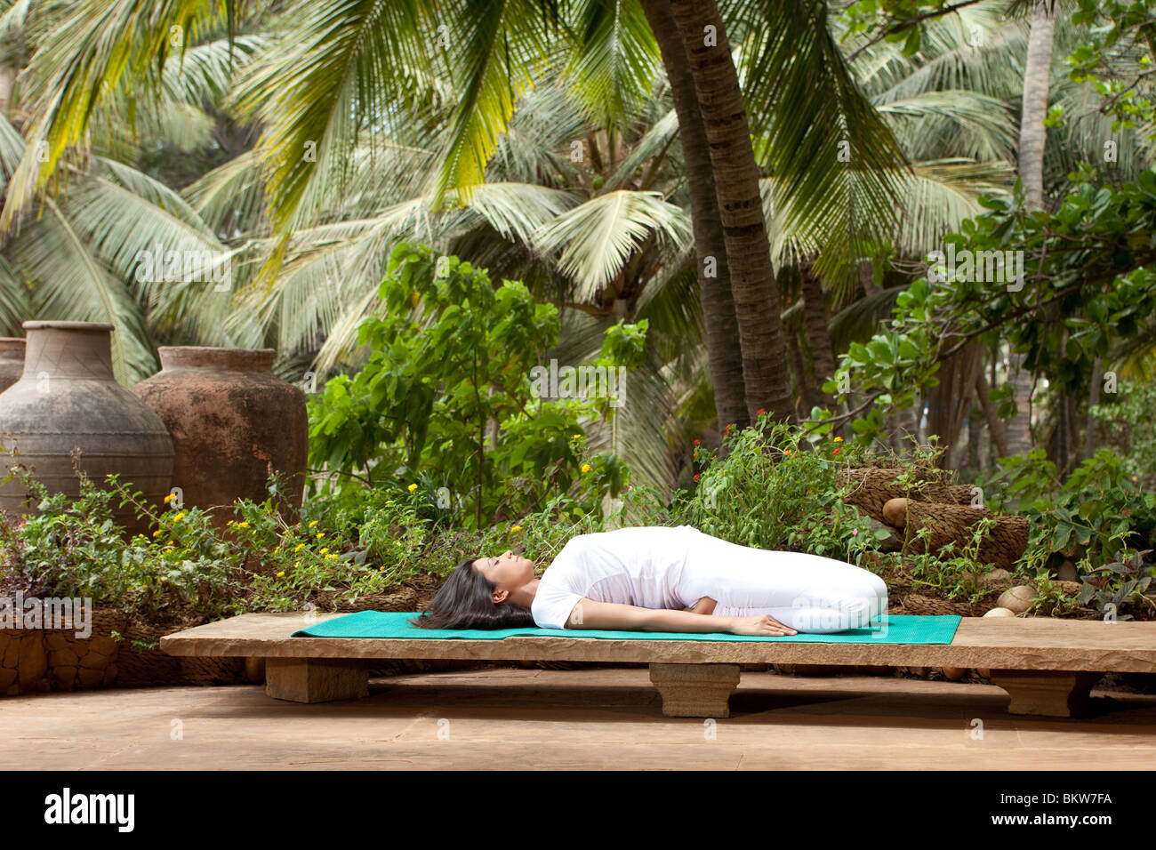 Woman in yoga position in the garden Stock Photo - Alamy