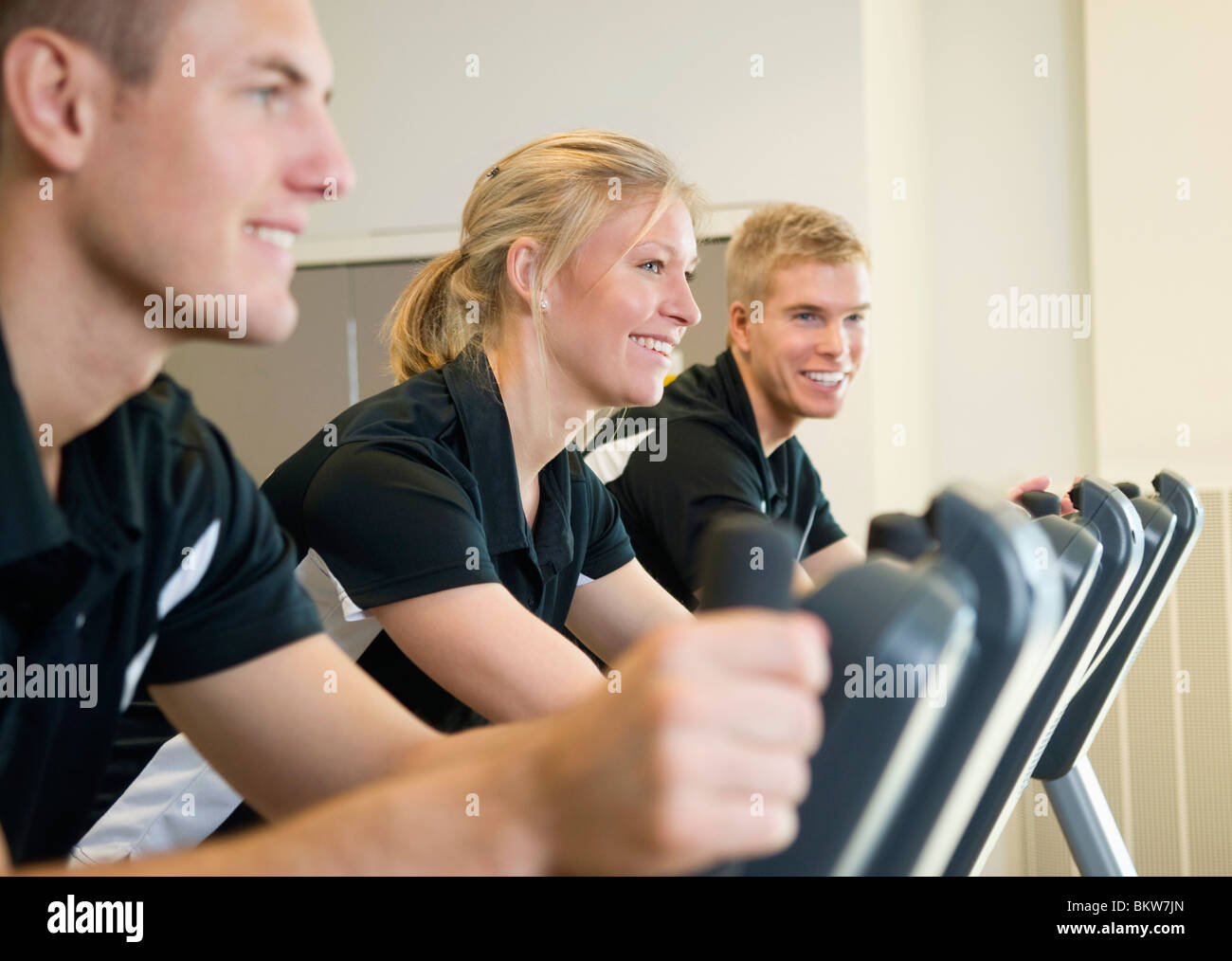 Three smiling people working out Stock Photo - Alamy