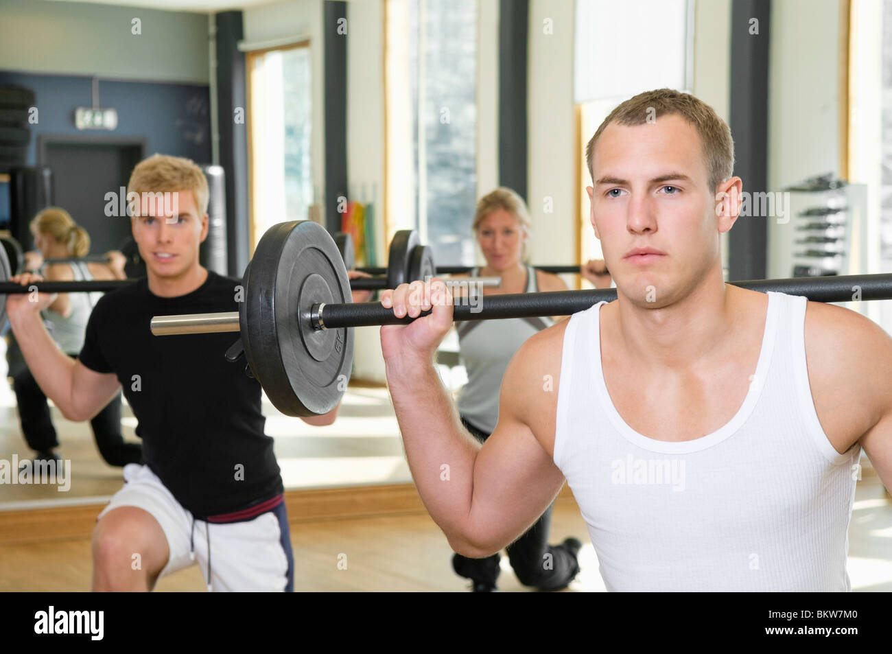 Three friends lifting weights Stock Photo - Alamy