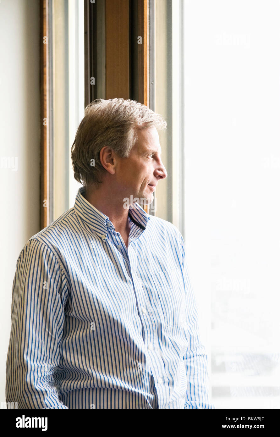 Man looking out through the window Stock Photo - Alamy