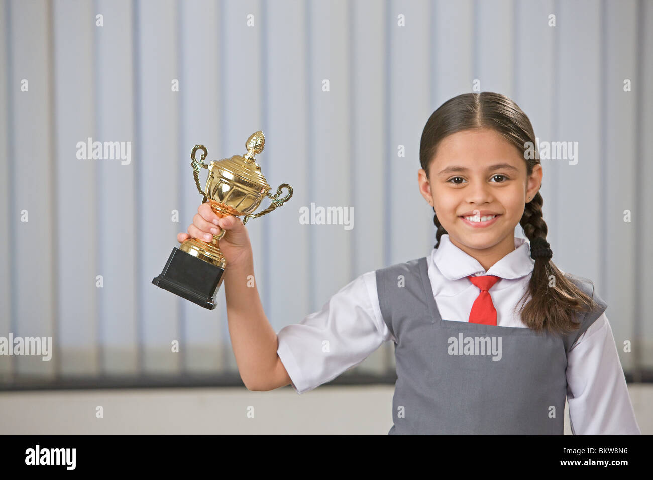 One school girl holding a trophy, smiling Stock Photo - Alamy