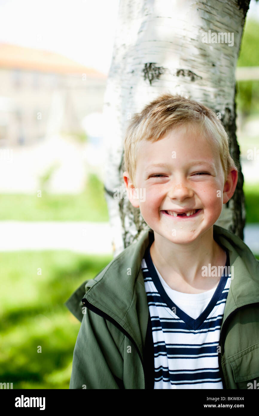 Happy boy leaning against tree Stock Photo - Alamy Happy boy leaning against tree Stock Photo - Alamy