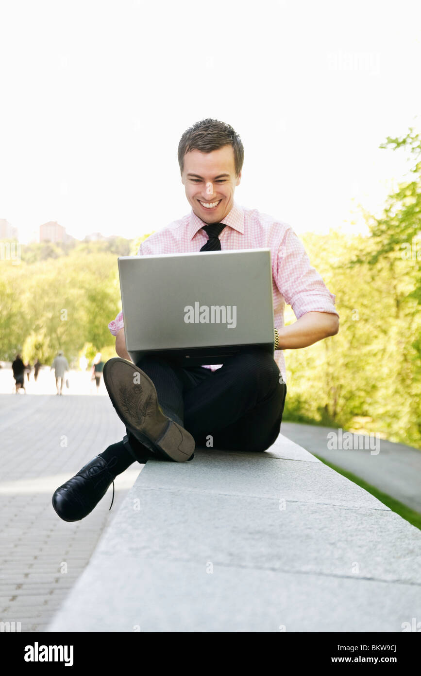Man sitting on wall Stock Photo - Alamy