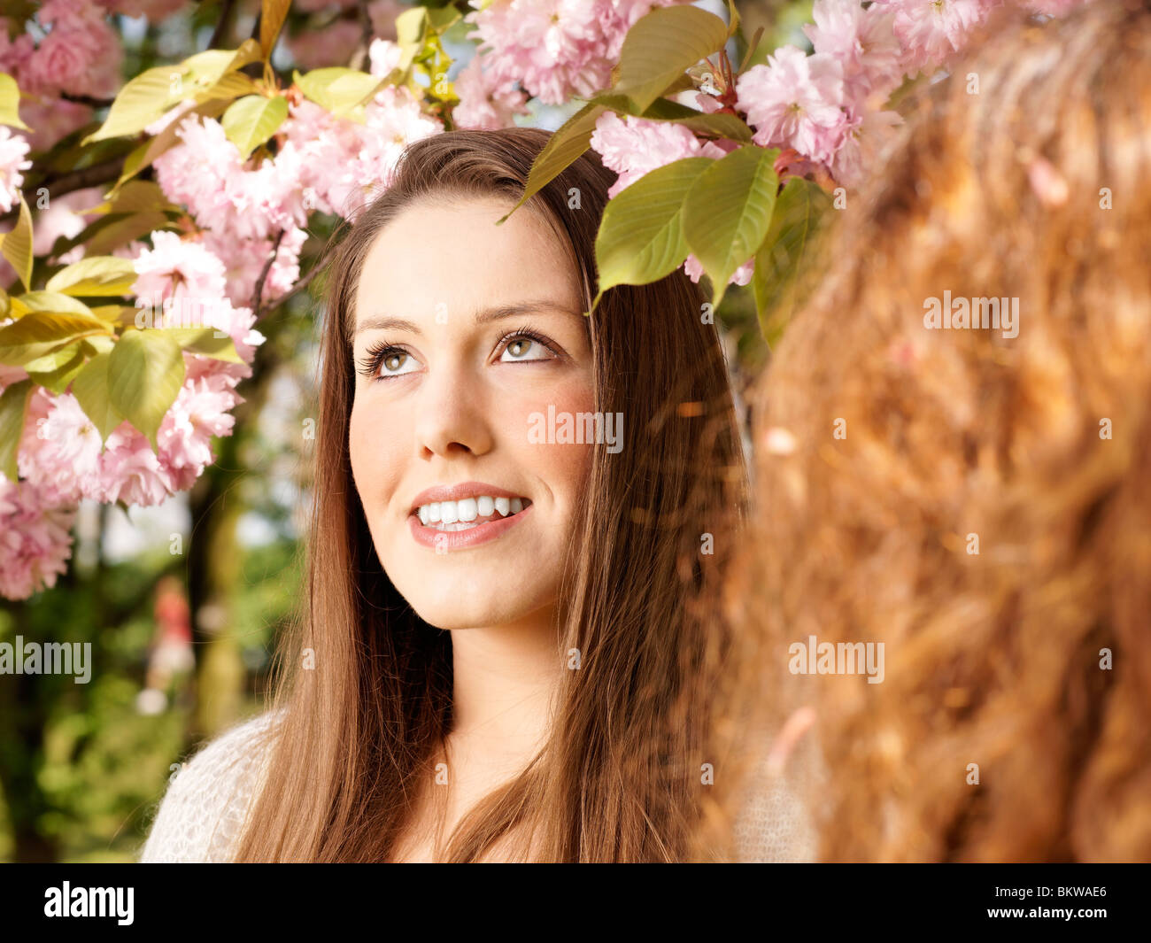German girl chatting with a friend in the park Stock Photo - Alamy