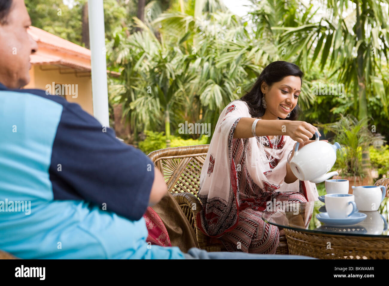 Daughter serving tea to her parents Stock Photo - Alamy