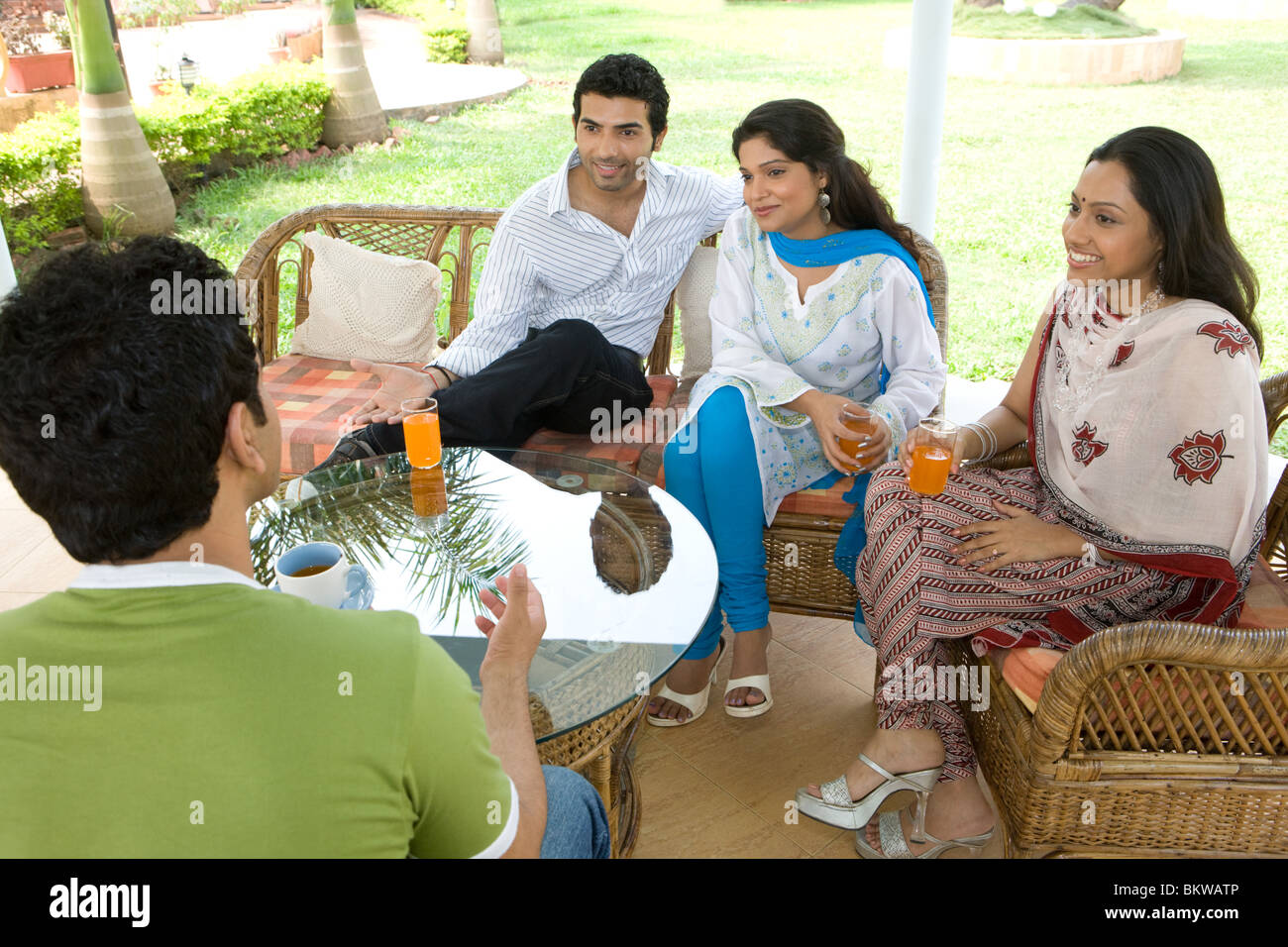 Four People talking in the garden Stock Photo - Alamy
