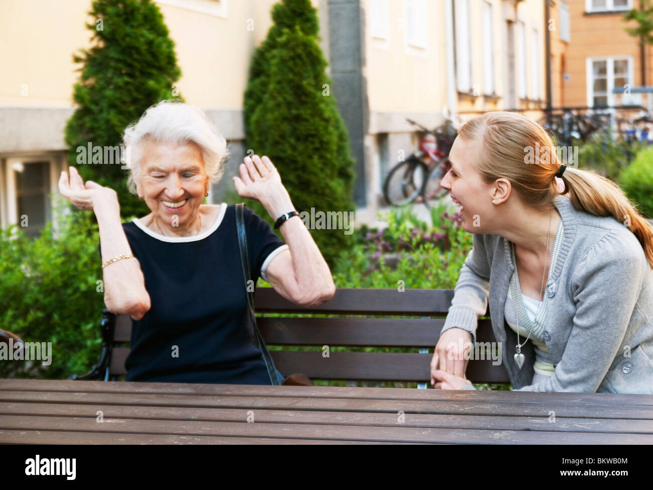 Women on bench talking Stock Photo - Alamy