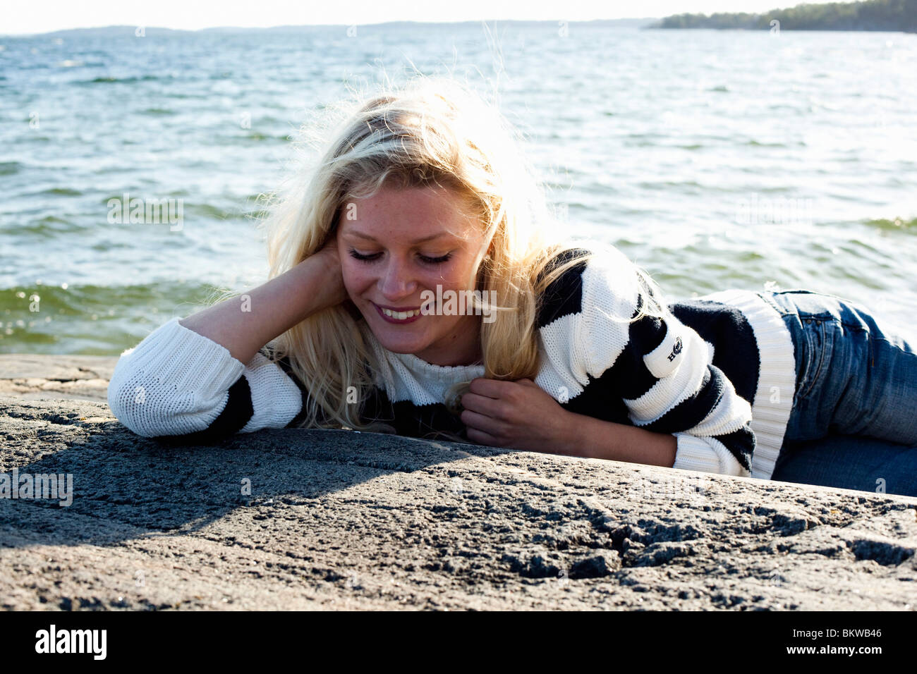 Woman leaning against rocks hi-res stock photography and images - Alamy
