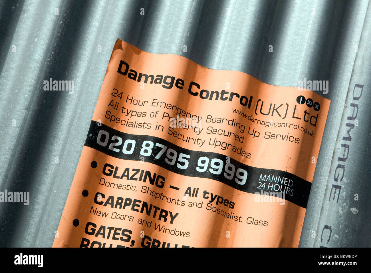 Damage control sign on boarded-up shop, London Stock Photo - Alamy